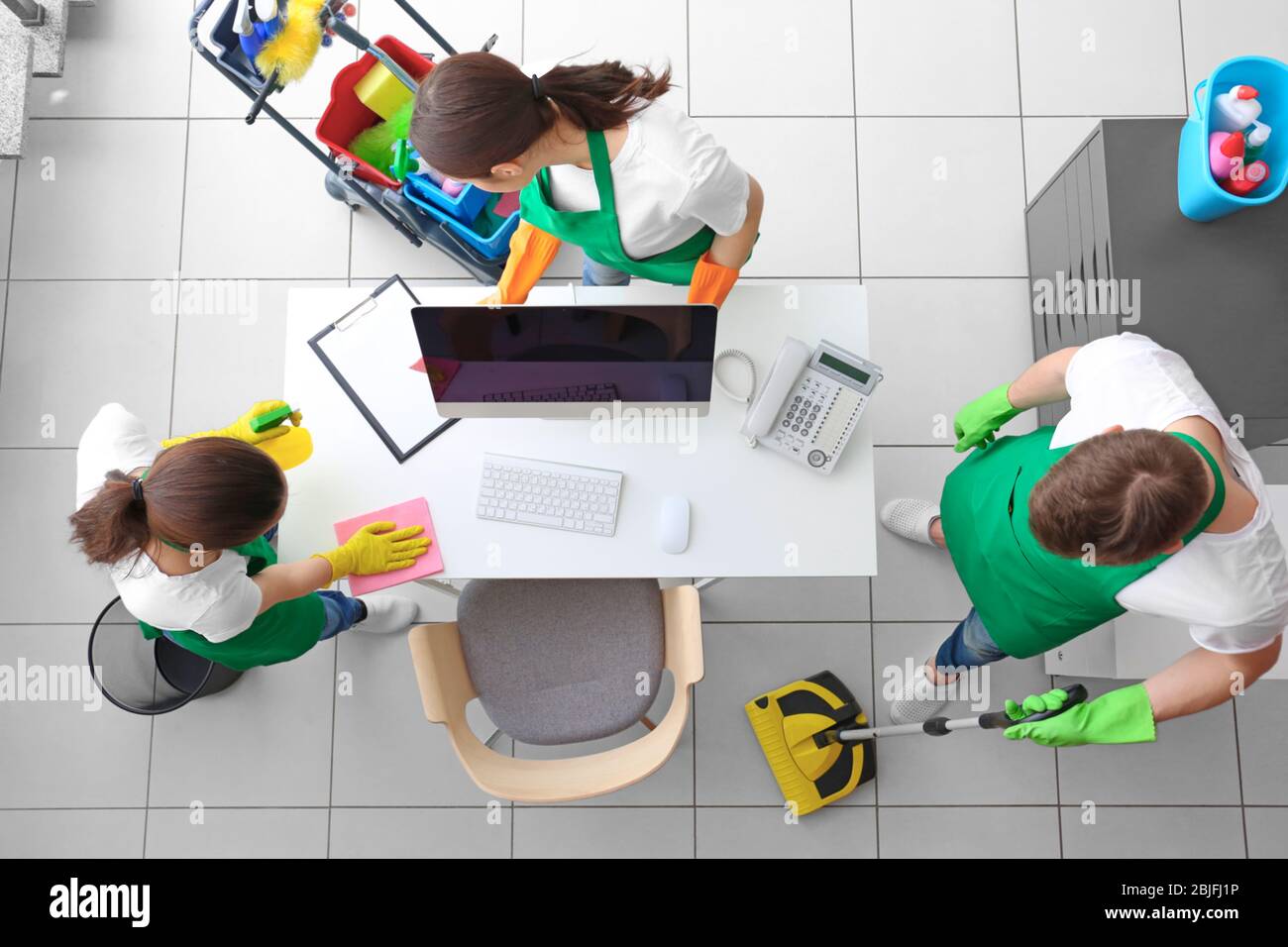 Cleaning service team working in office Stock Photo - Alamy