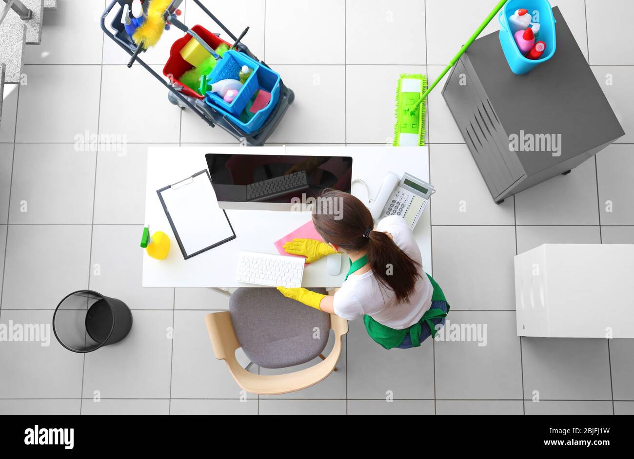 Young female cleaner at work in office Stock Photo - Alamy