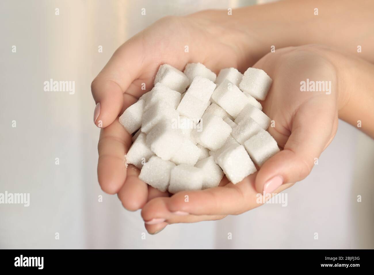 Female hands holding sugar cubes Stock Photo - Alamy