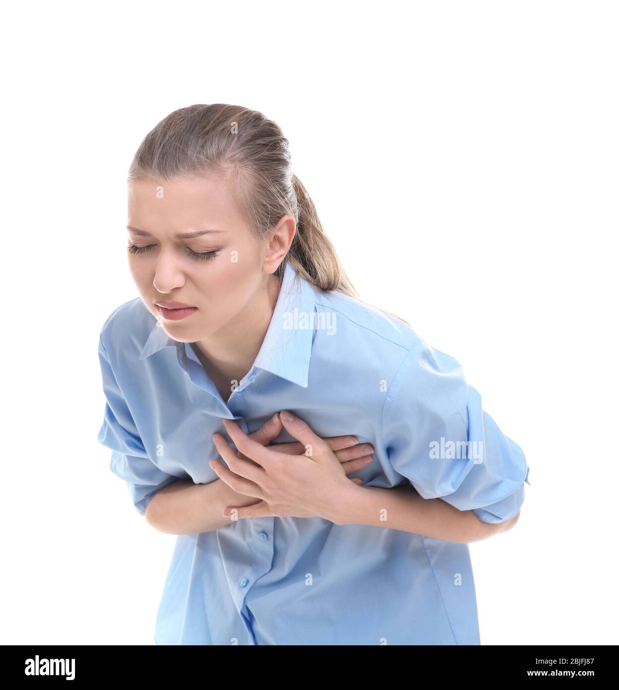 Heart attack concept. Young woman suffering from chest pain on white ...