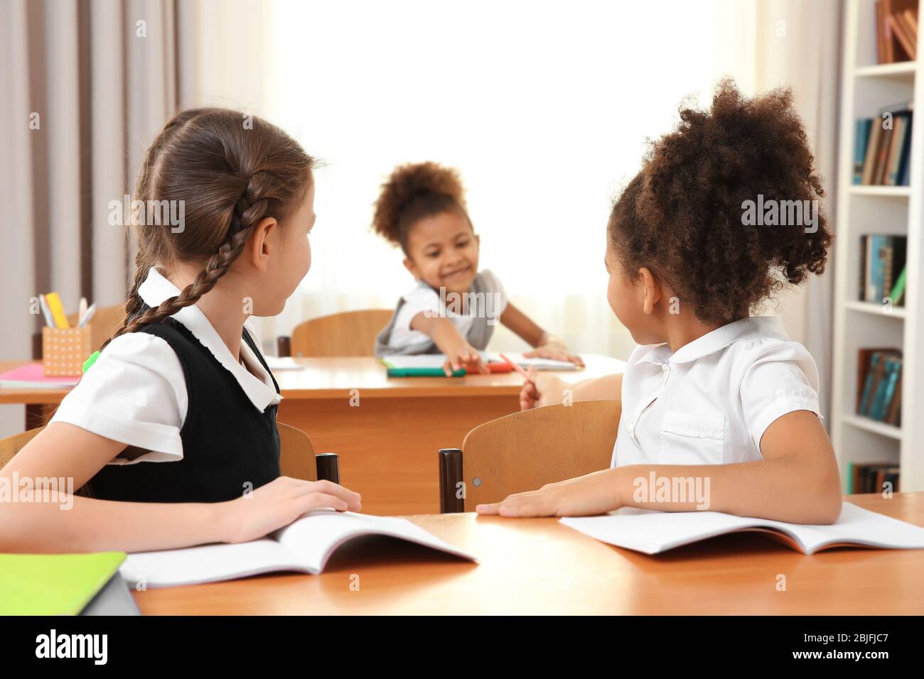 Beautiful elementary schoolgirls studying in classroom Stock Photo - Alamy