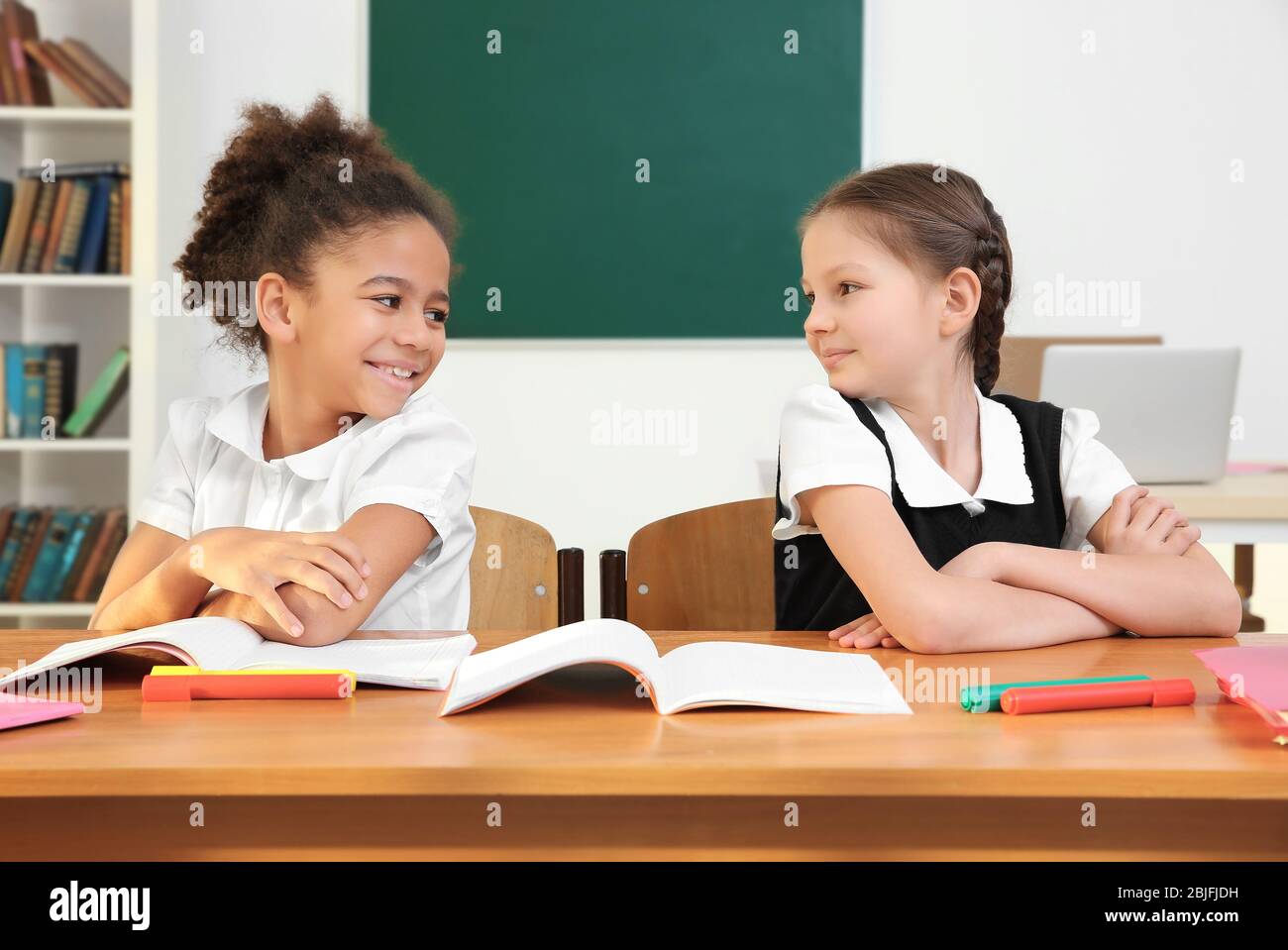 Beautiful elementary schoolgirls studying in classroom Stock Photo - Alamy