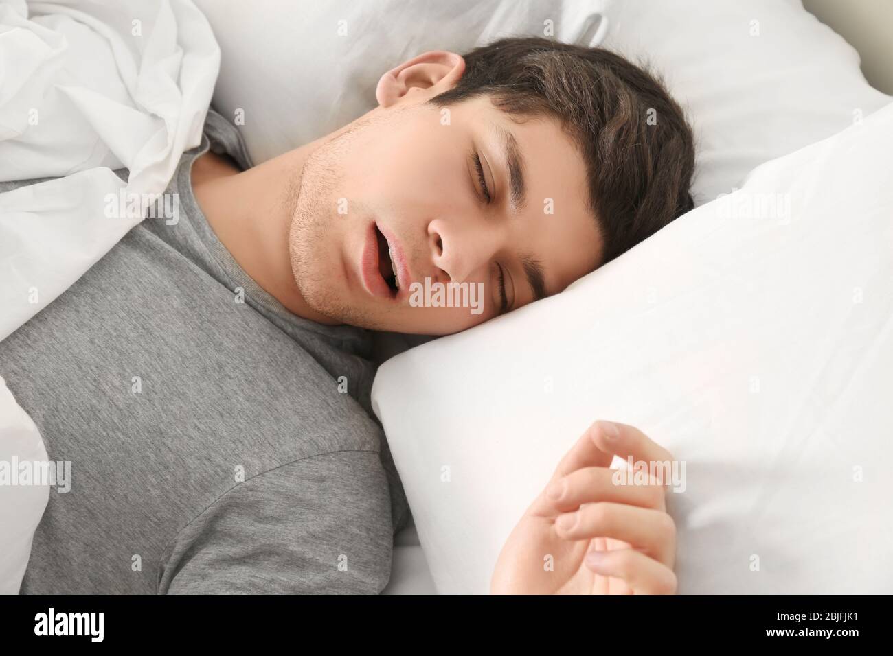 Handsome young man sleeping in bed at home Stock Photo - Alamy