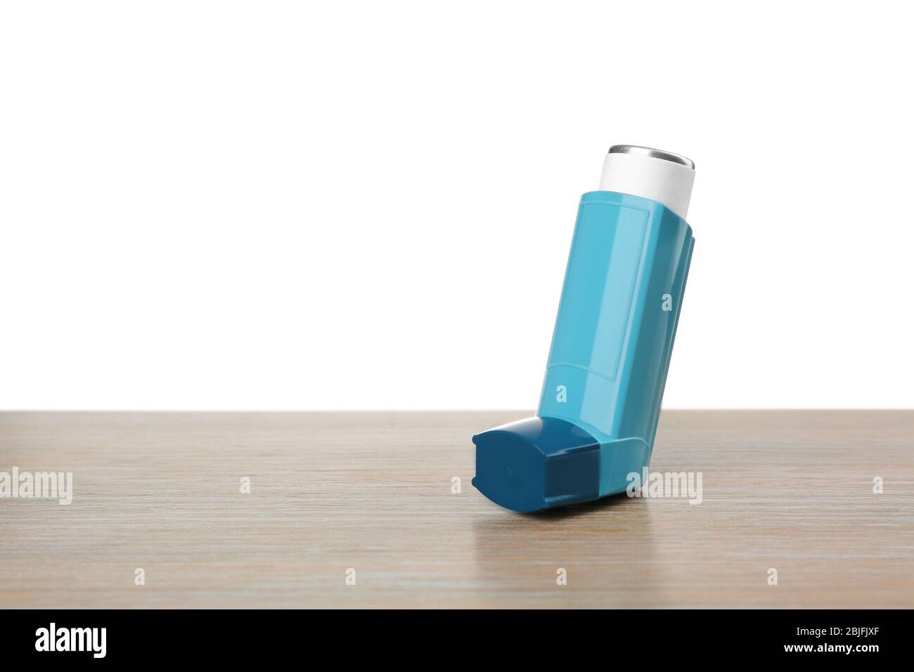 Asthma inhaler on wooden table Stock Photo - Alamy