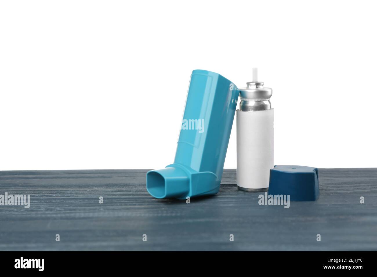 Asthma inhaler on wooden table Stock Photo - Alamy