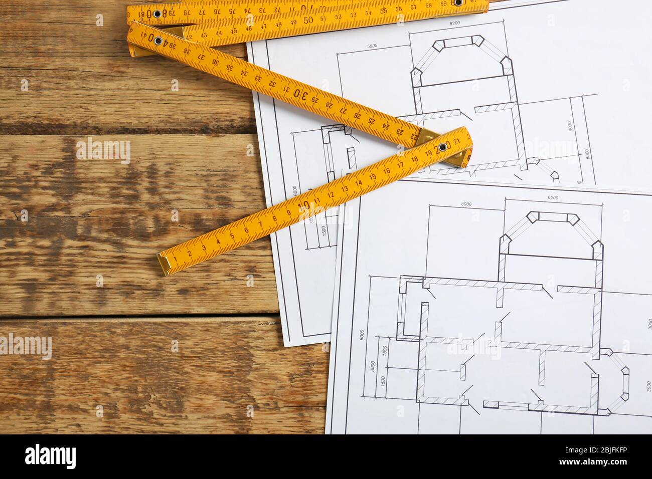 Engineering blueprints with ruler on wooden background Stock Photo - Alamy
