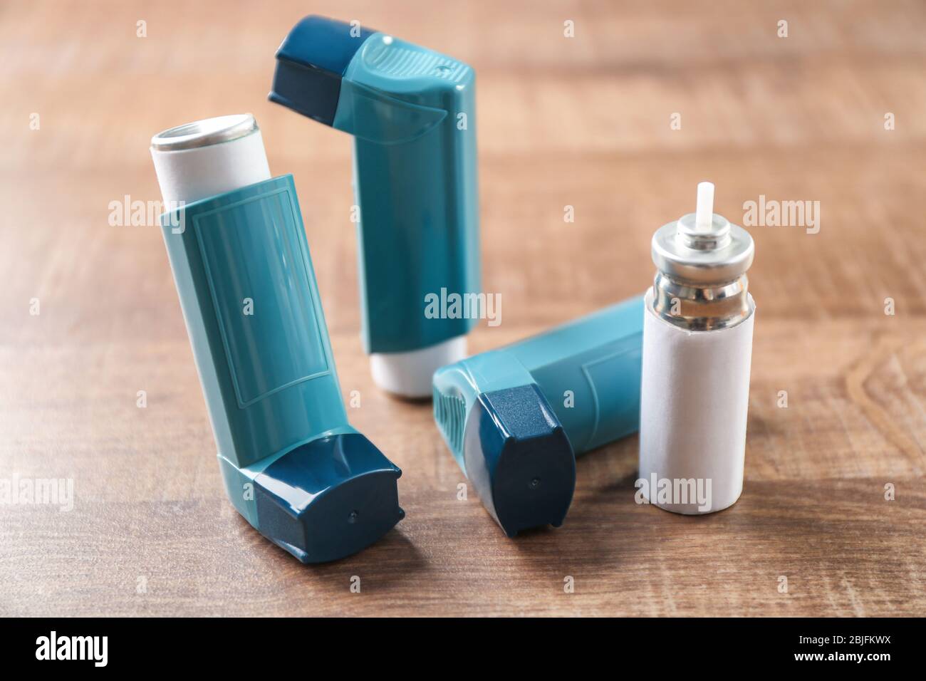Asthma inhalers with cartridge on wooden table Stock Photo - Alamy