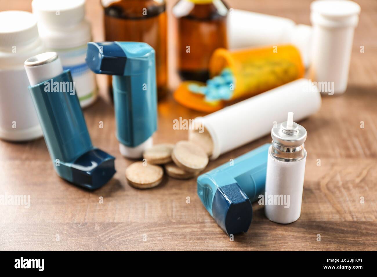 Asthma inhalers with medicines on wooden table Stock Photo - Alamy
