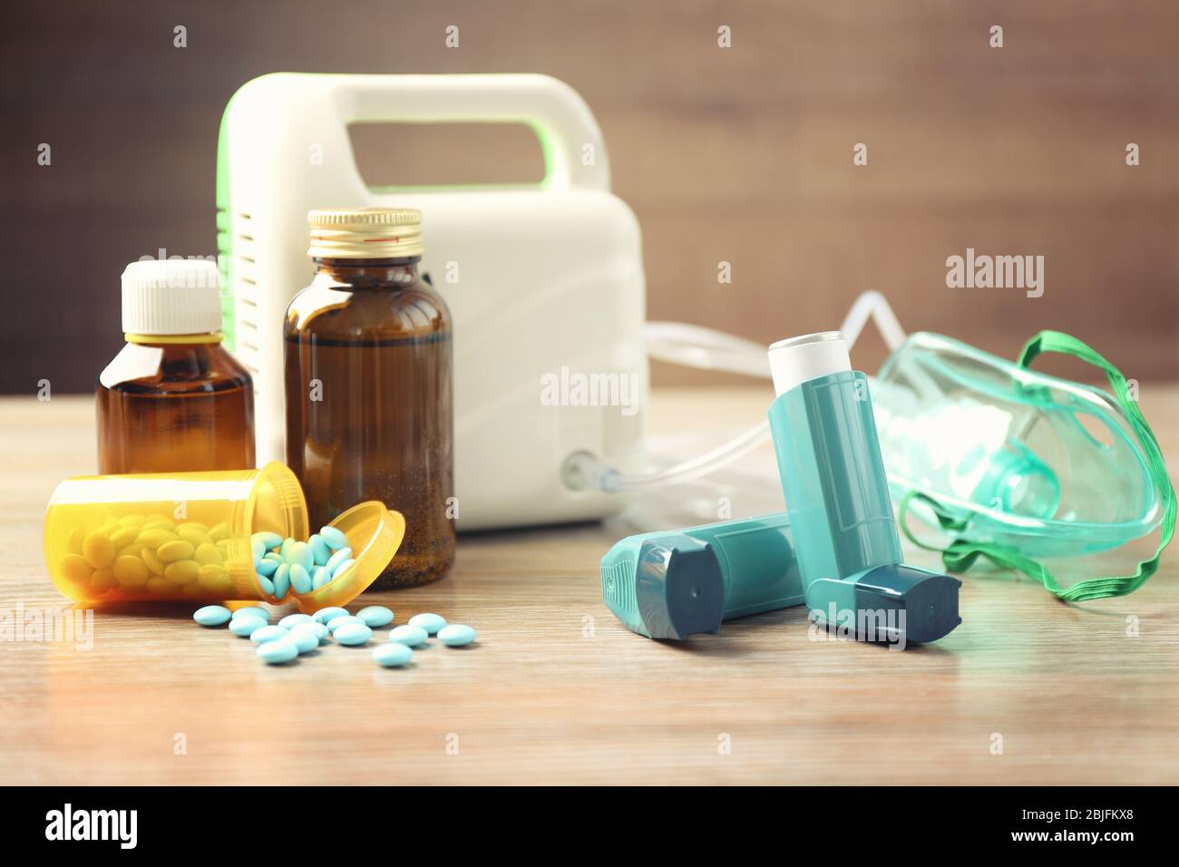 Asthma inhalers, medicines and nebuliser on wooden table Stock Photo ...