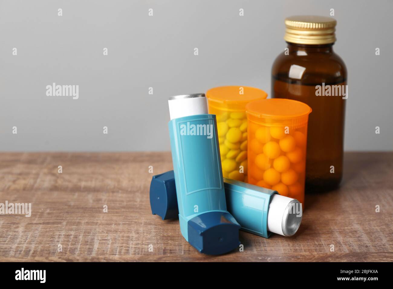 Asthma inhalers with medicines on wooden table Stock Photo - Alamy