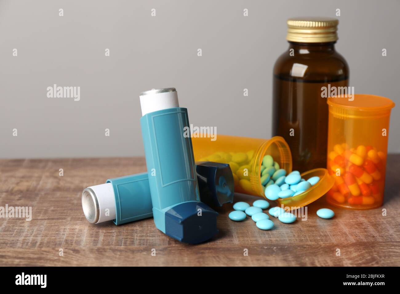 Asthma inhalers with medicines on wooden table Stock Photo - Alamy