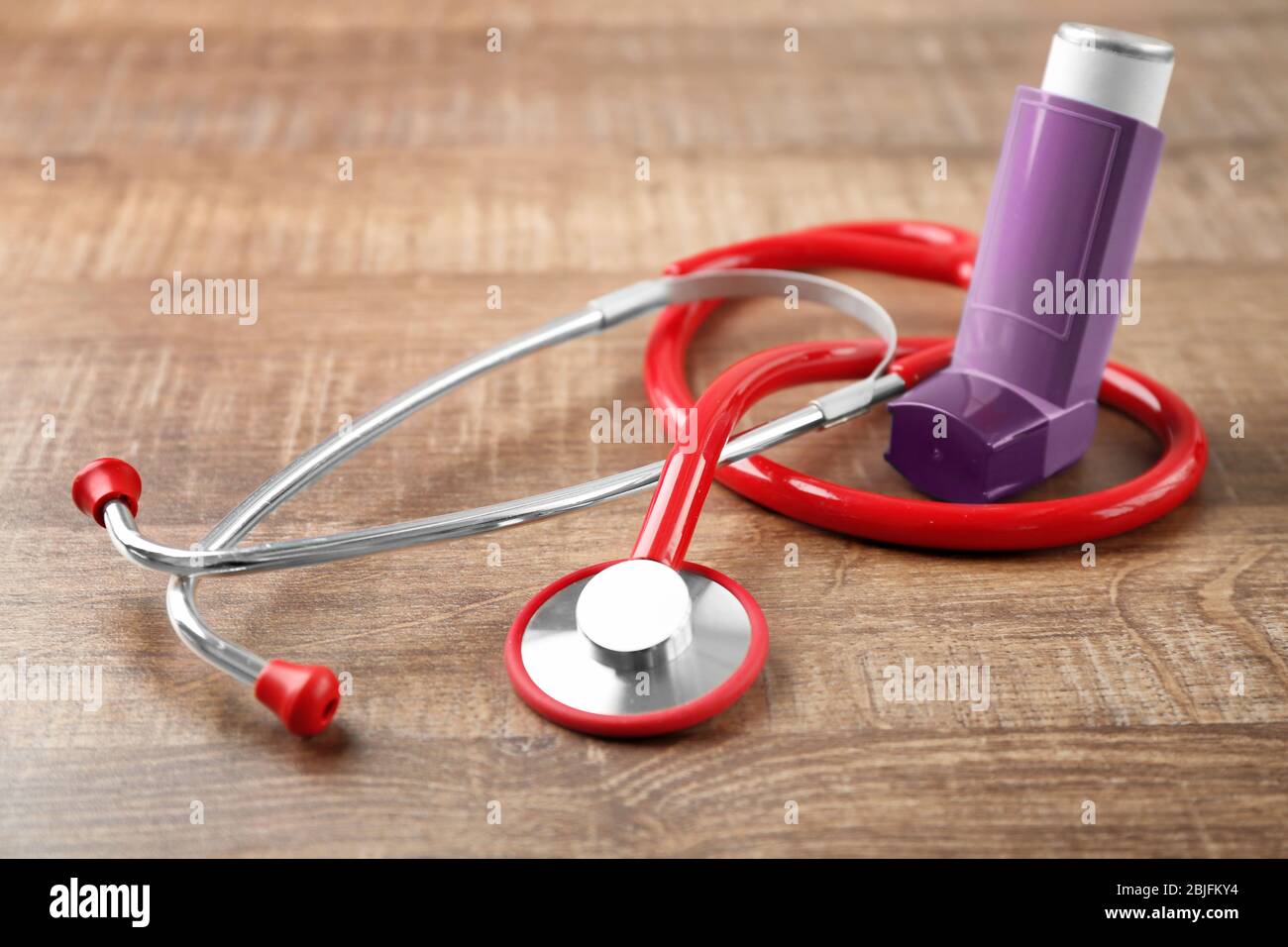 Asthma inhaler with stethoscope on wooden table Stock Photo - Alamy