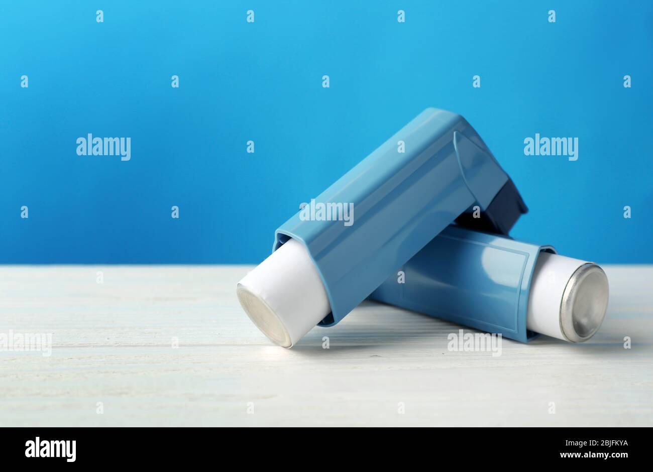 Asthma inhalers on blue background Stock Photo - Alamy