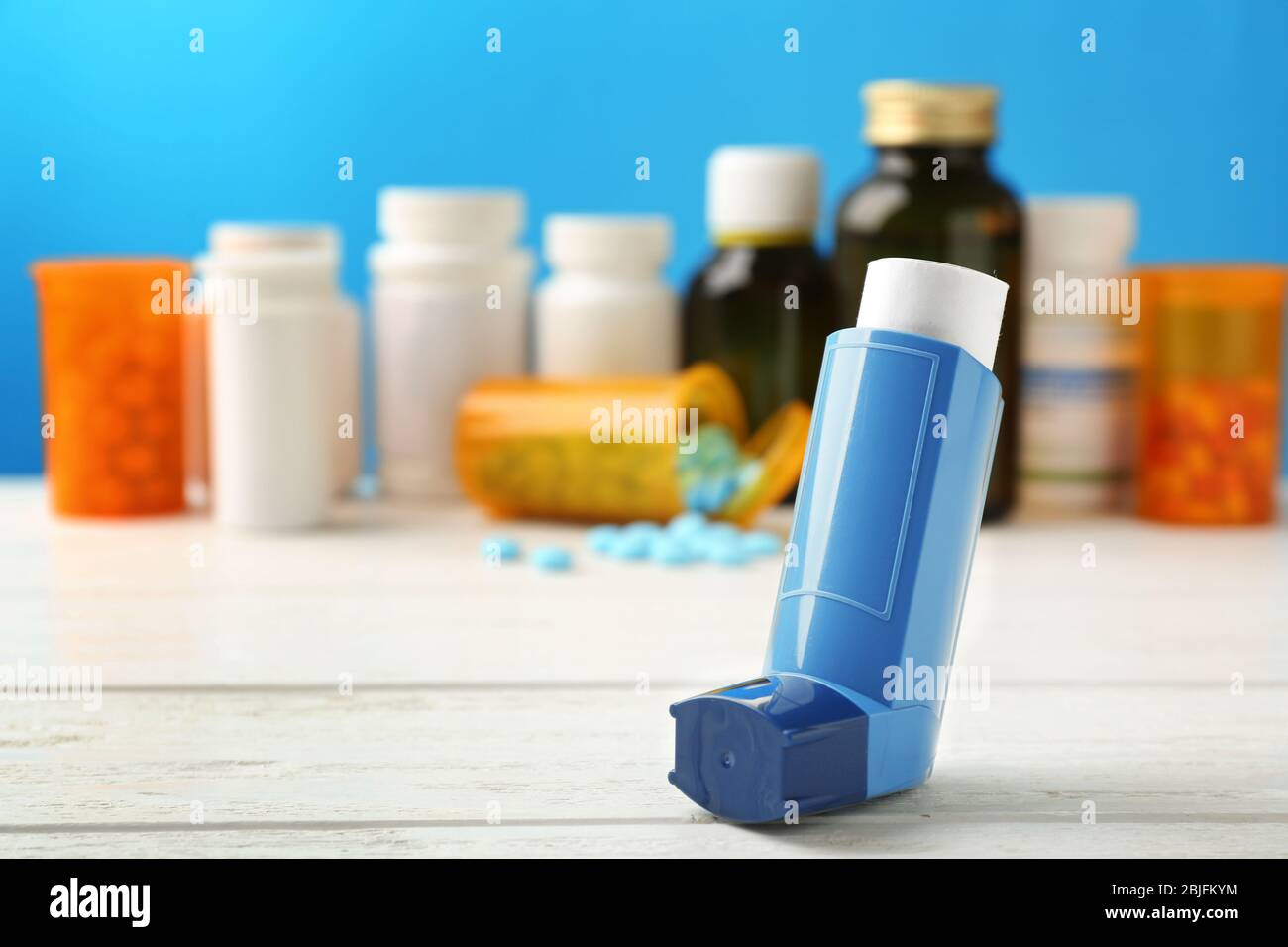 Asthma inhaler with medicines on blue background Stock Photo - Alamy