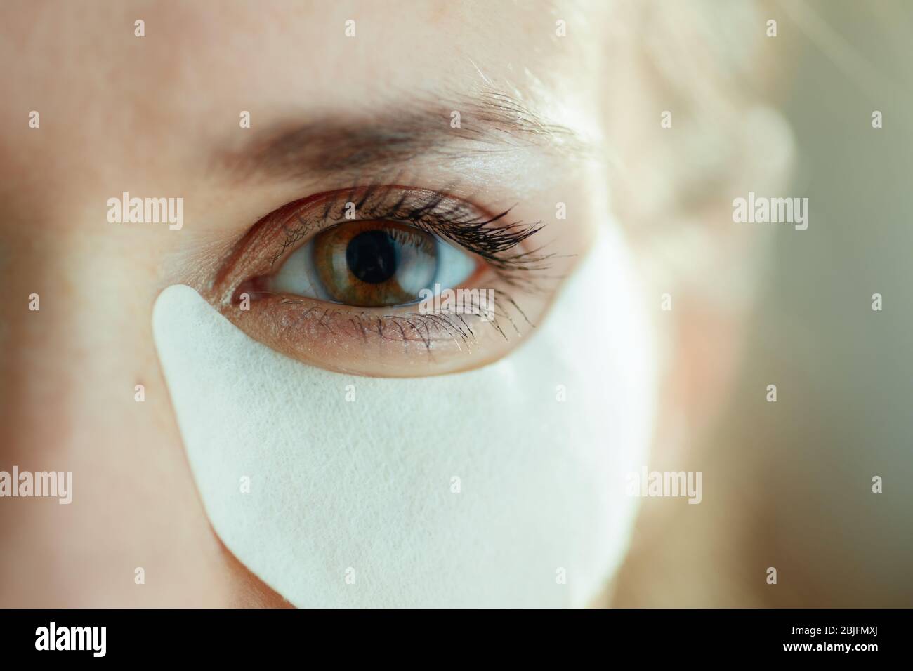 Closeup on woman in the house in sunny day using white cotton eye ...