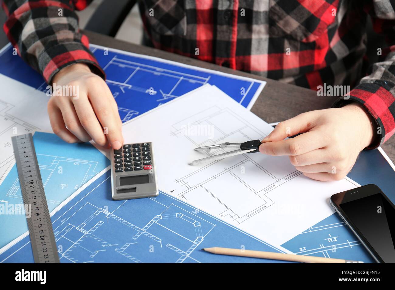 Male engineer hands working with blueprints on table Stock Photo - Alamy