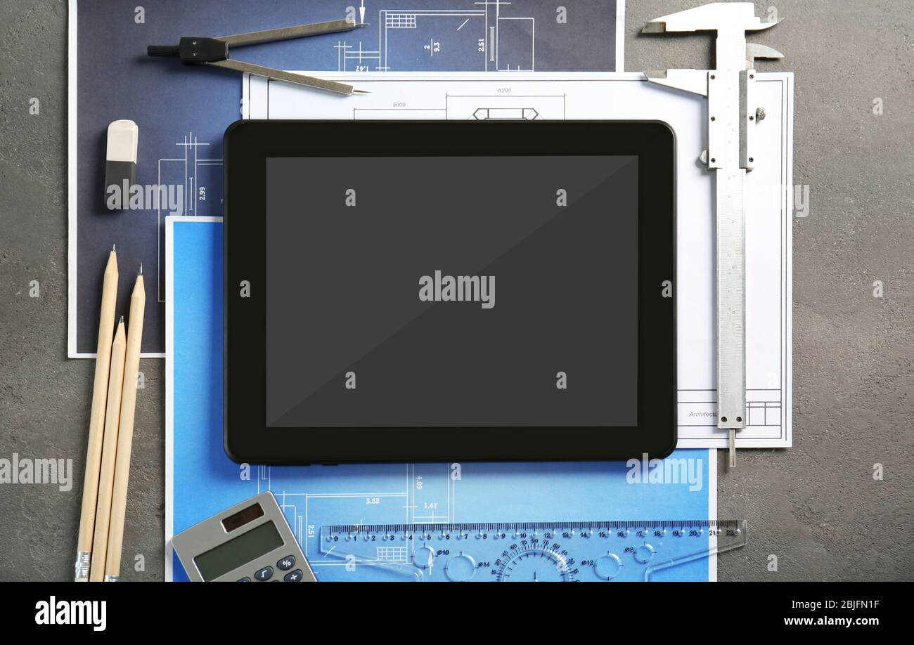 Tablet with blueprints and engineer equipment on table Stock Photo - Alamy