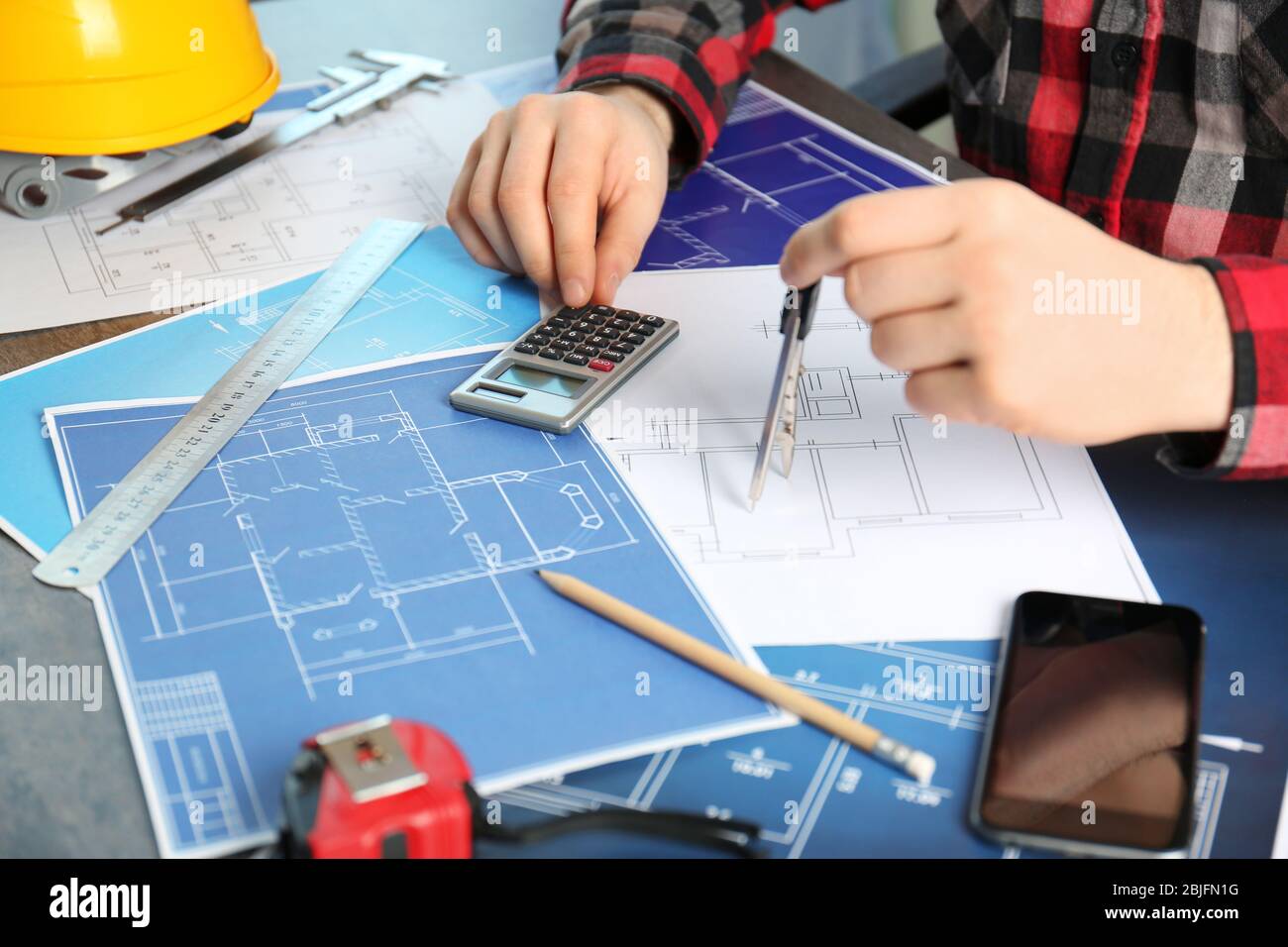 Male engineer hands working with blueprints on table Stock Photo - Alamy