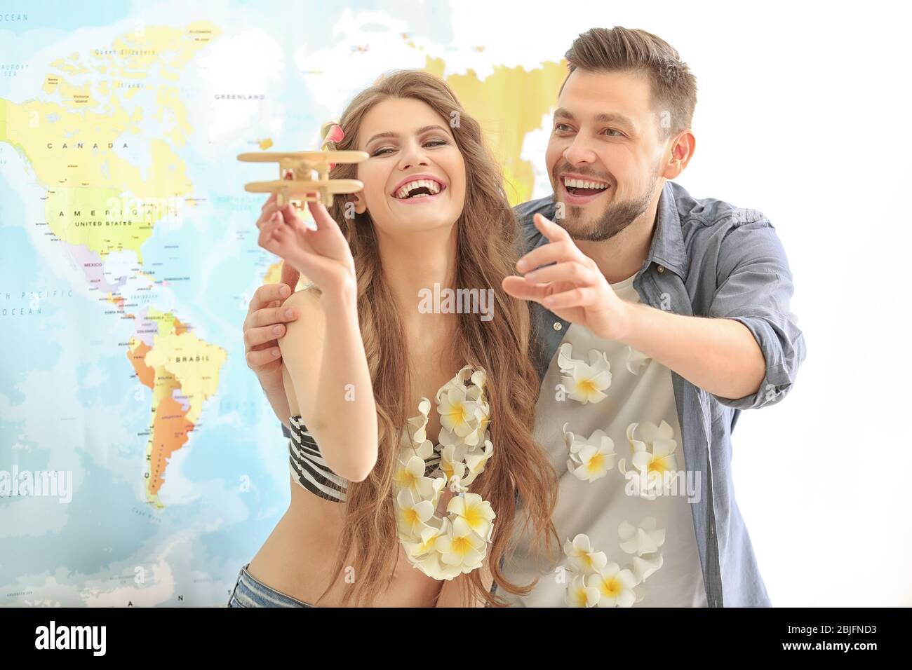 Adventure concept. Cheerful young couple imagining future travel on map ...