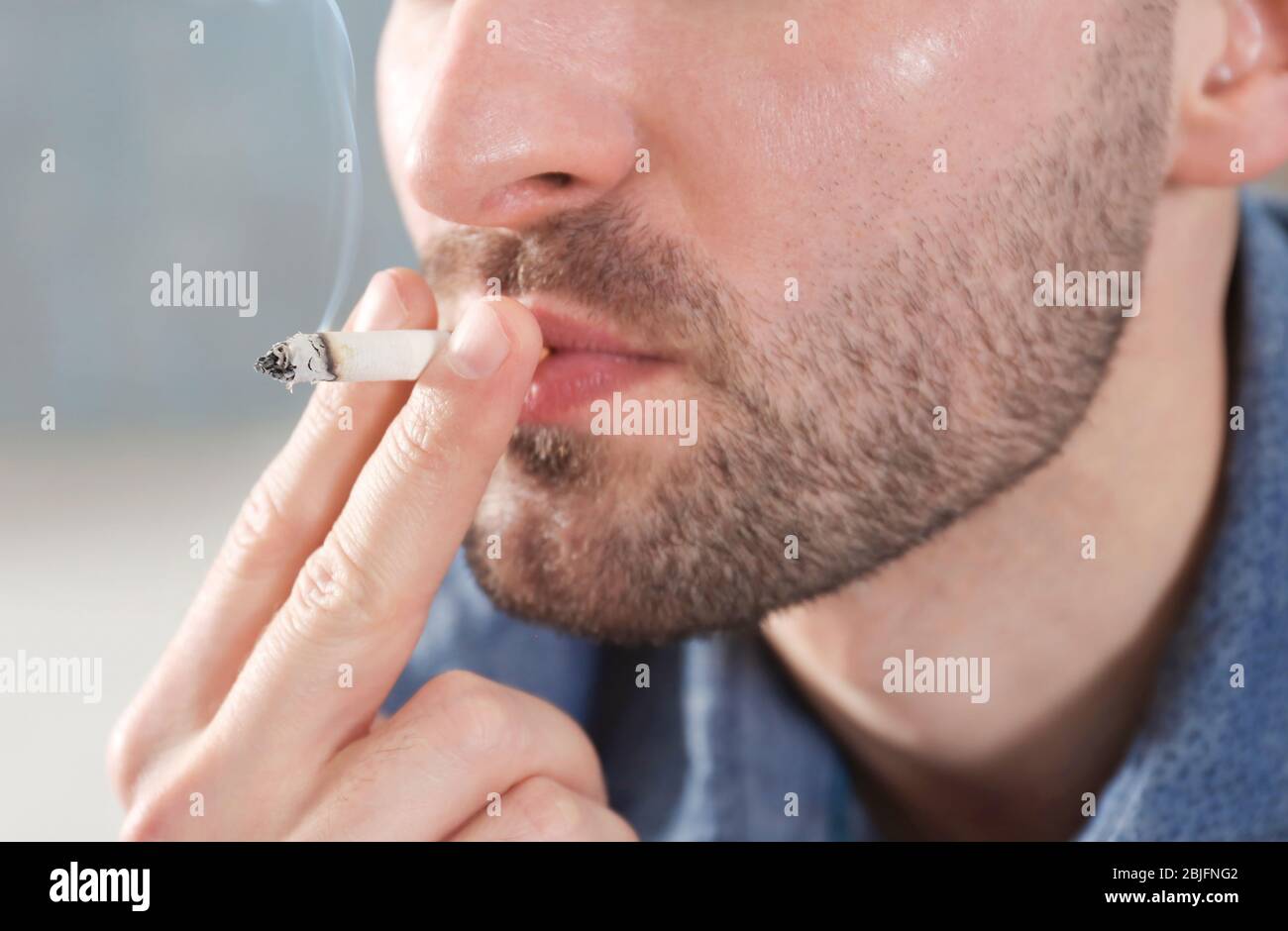 Handsome man smoking cigarette hi-res stock photography and images - Alamy