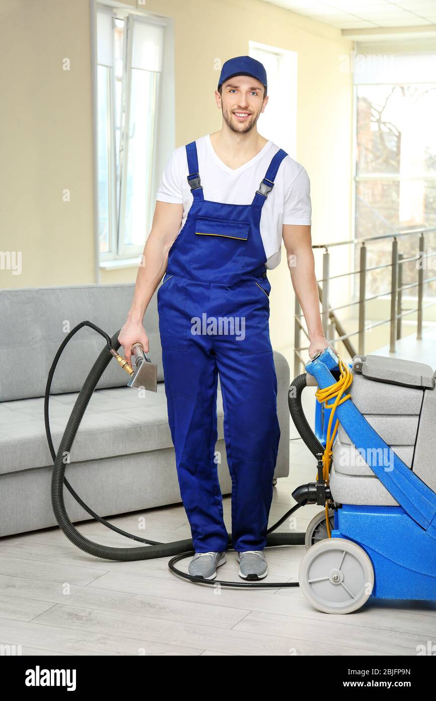 Man in uniform cleaning flat Stock Photo - Alamy