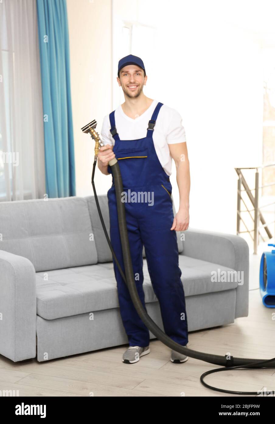 Man in uniform cleaning flat Stock Photo - Alamy