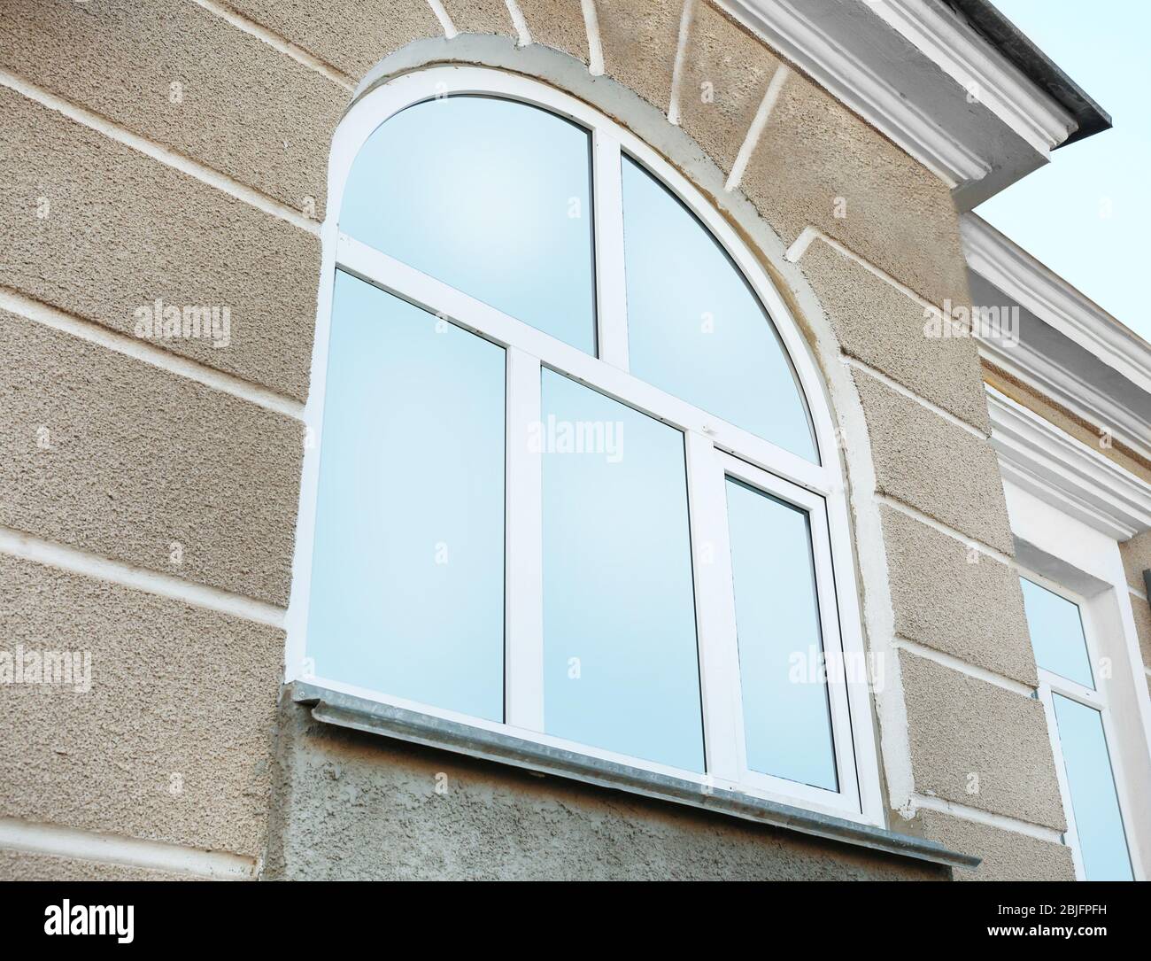 Arched window with tinted glass on grey wall background Stock Photo - Alamy
