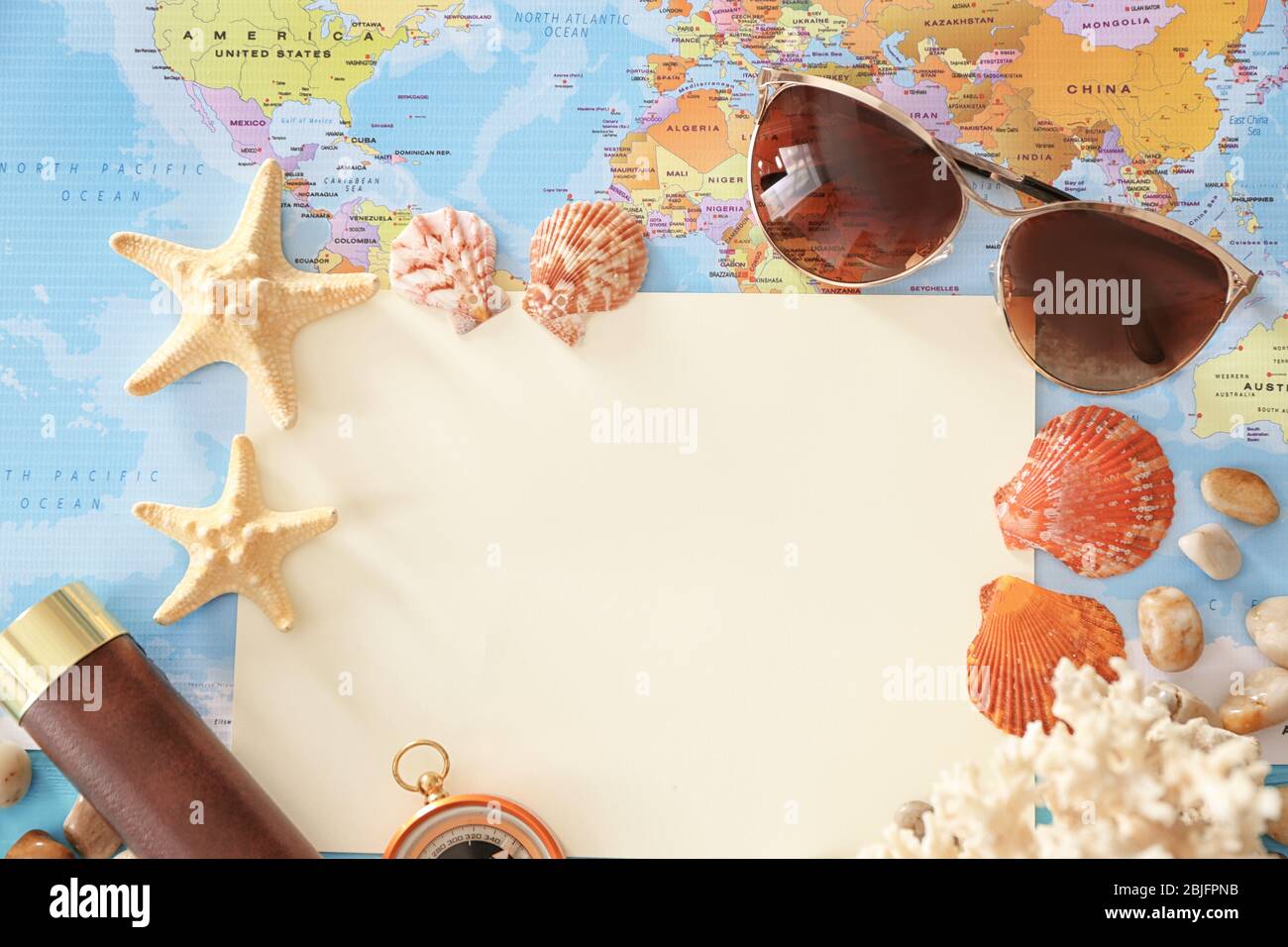 Travel concept. Composition with paper and sea shells on world map ...