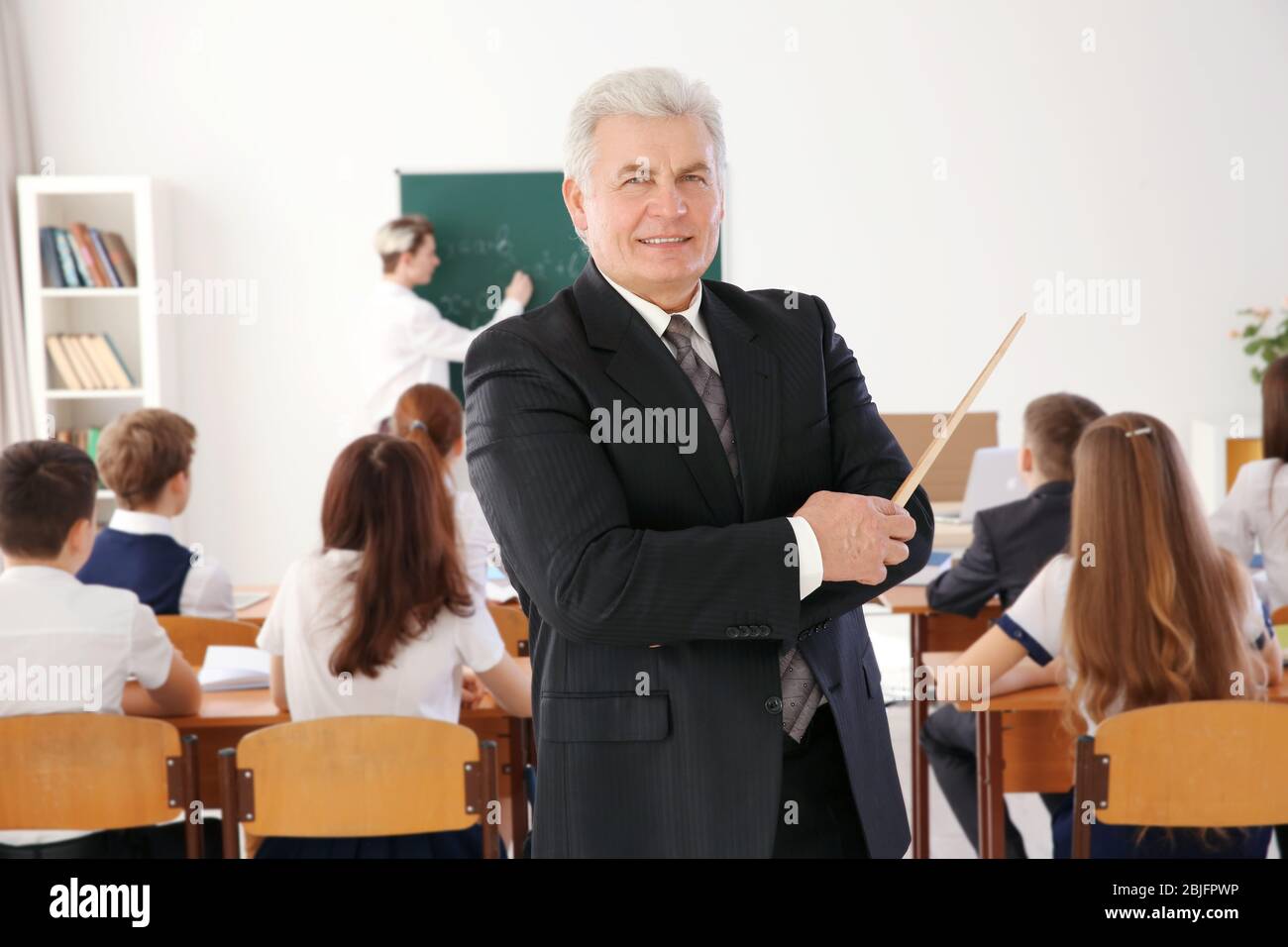 Portrait of senior teacher in classroom Stock Photo - Alamy