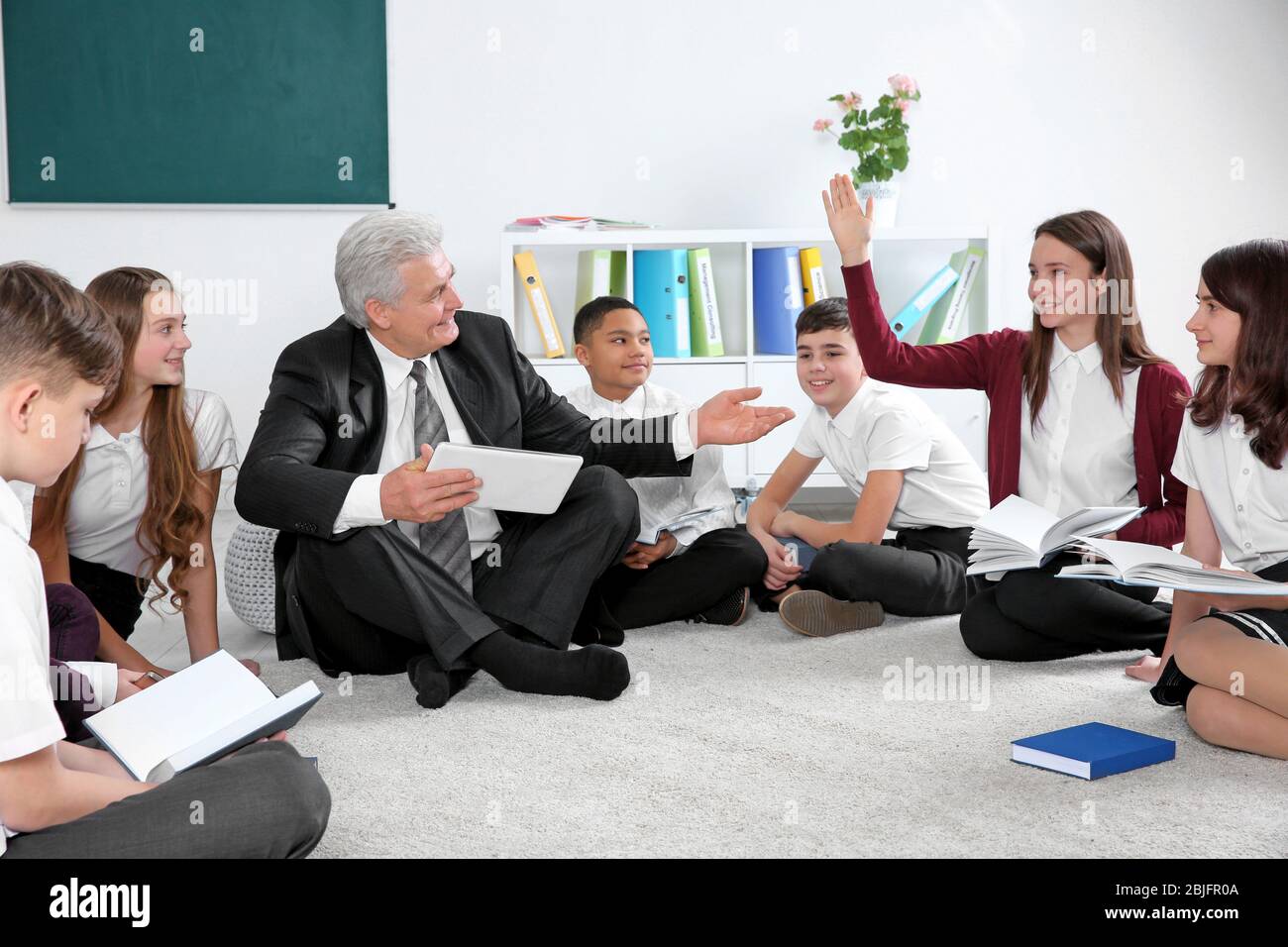 Senior teacher conducting lesson at school Stock Photo - Alamy