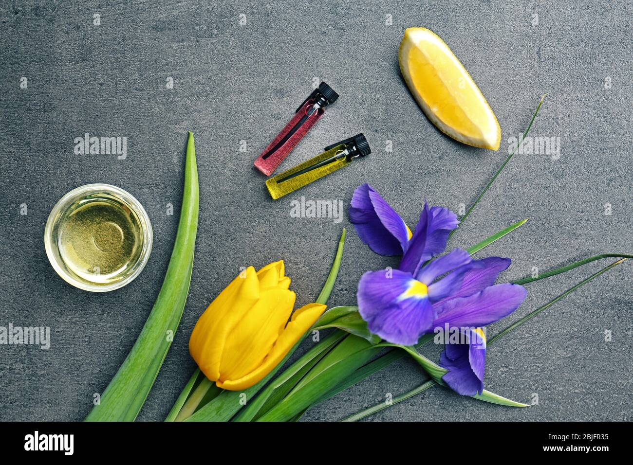 Beautiful composition with perfume samples and flowers on gray ...