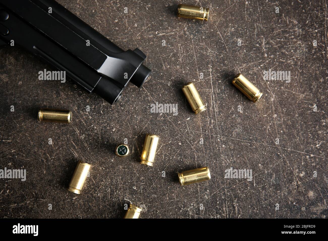 Bullets and gun on gray table Stock Photo - Alamy
