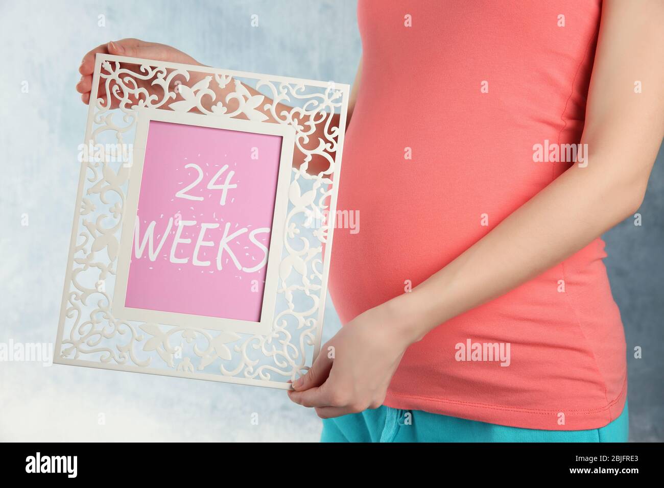 Pregnant woman holding vintage frame with words 24 WEEKS Stock Photo ...
