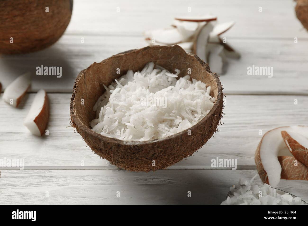 Grated coconut in shell on wooden background Stock Photo - Alamy