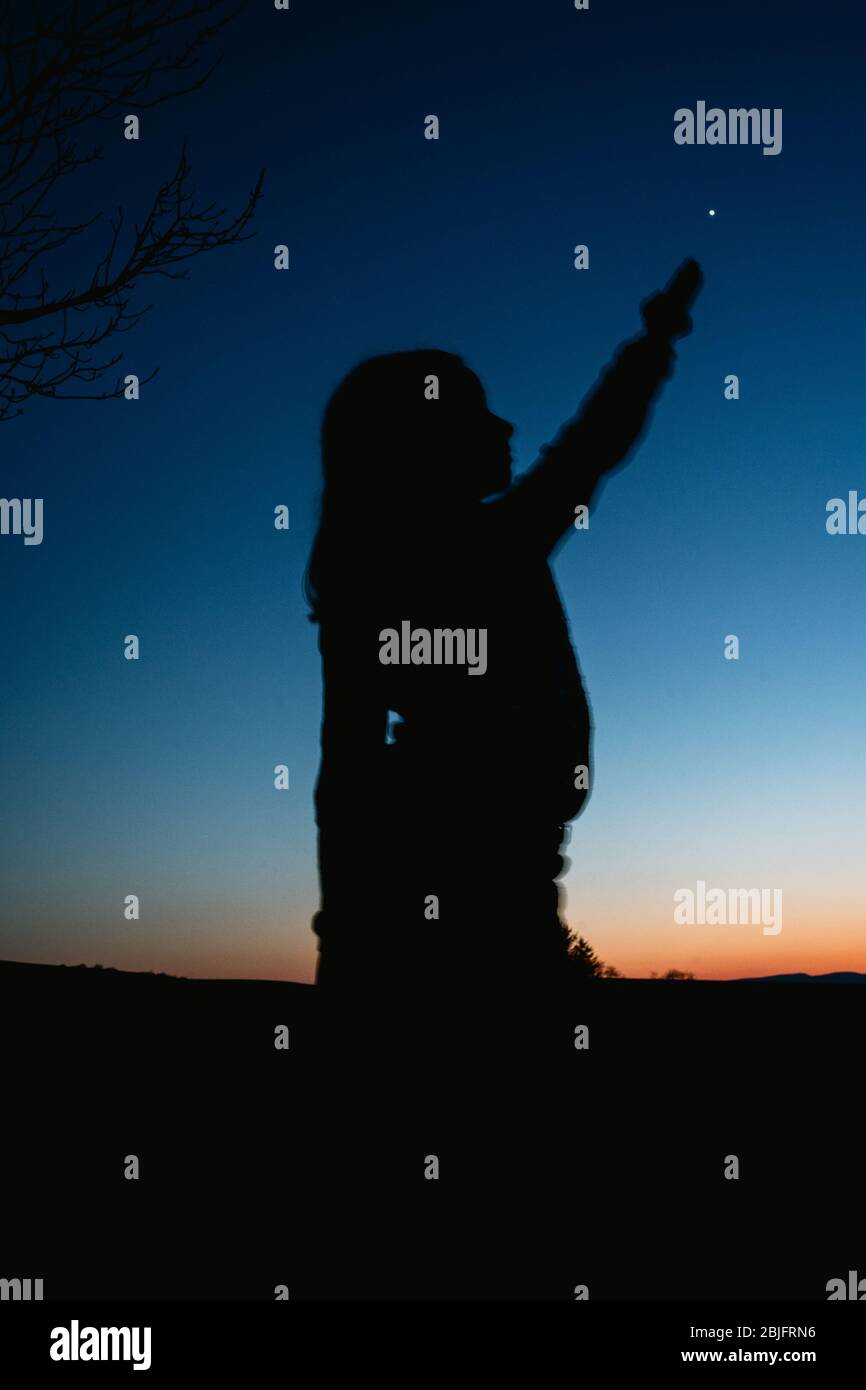 Girl reaching for a star at sunset Stock Photo - Alamy