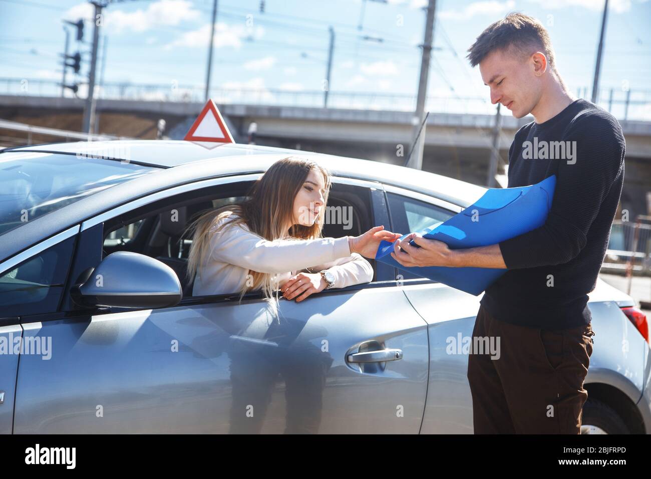 Driving instructor and woman student in examination car Stock Photo - Alamy