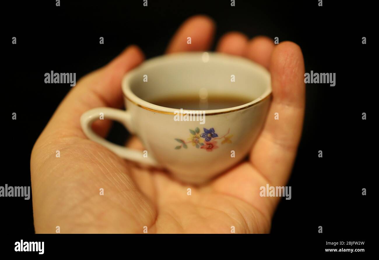a small cup of coffee in your hand Stock Photo - Alamy