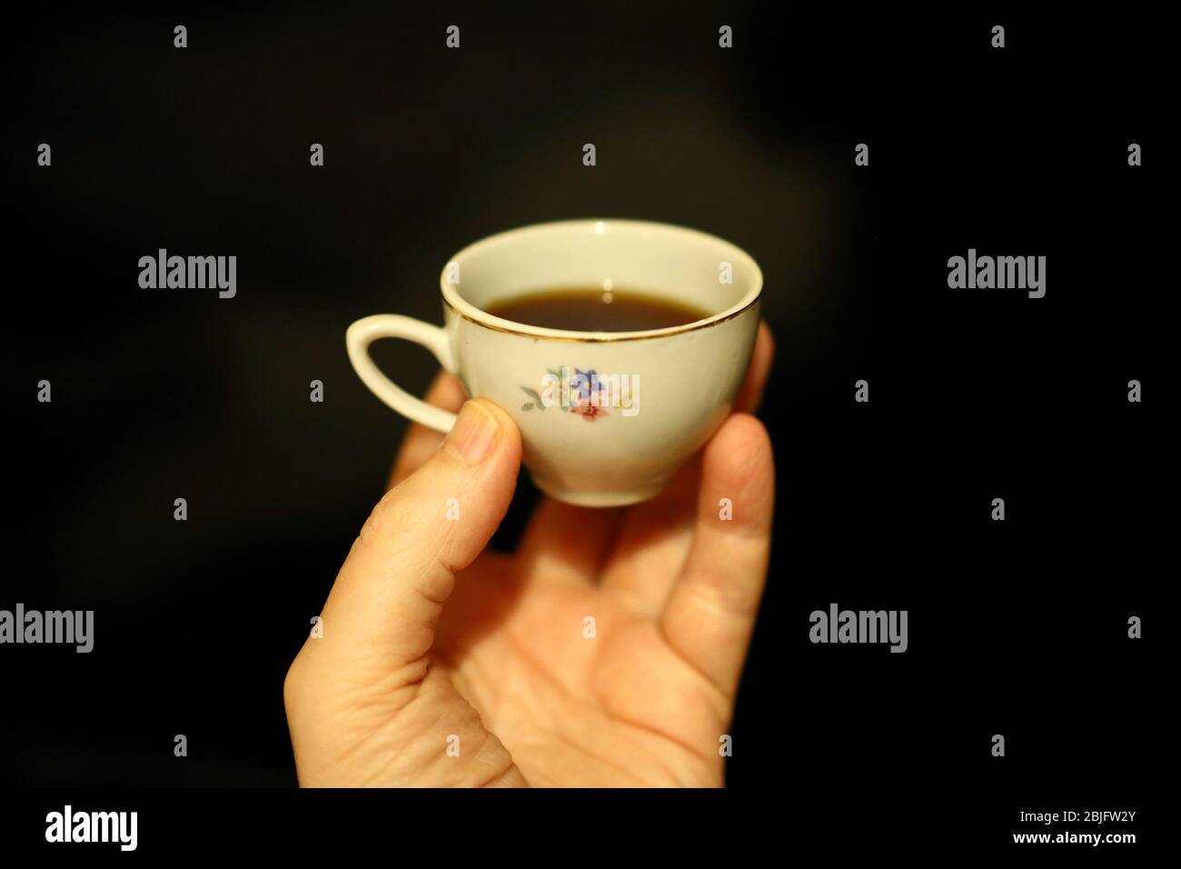 a small cup of coffee in your hand Stock Photo - Alamy