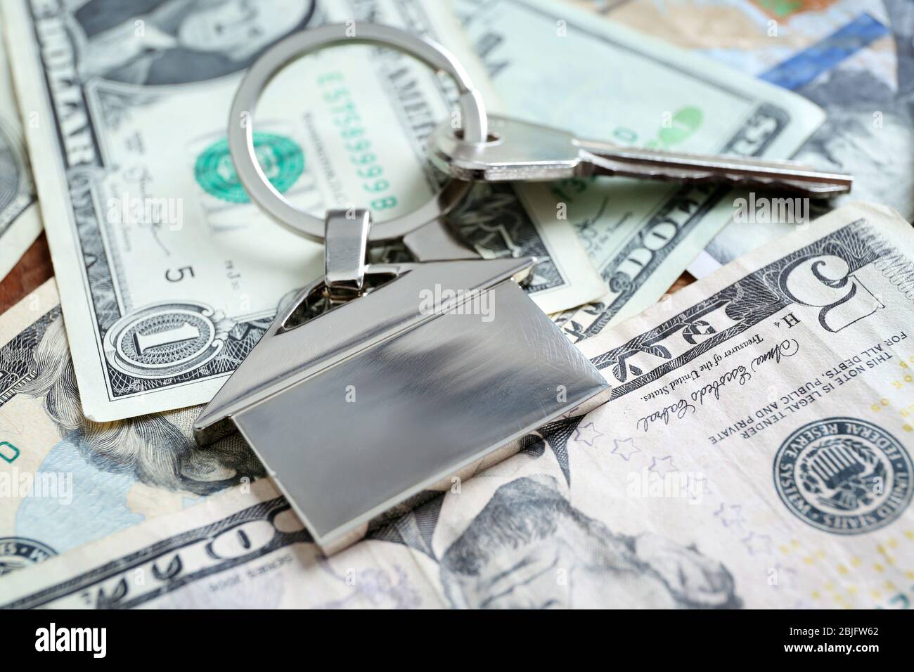 Savings concept. Key with trinket on money Stock Photo - Alamy