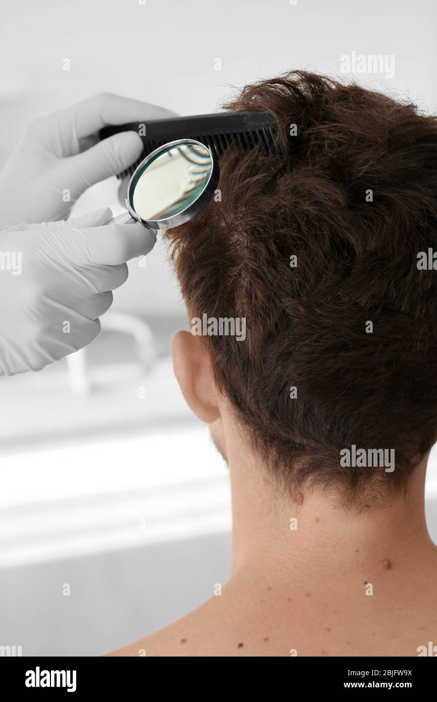 Dermatologist with magnifier examining patient in clinic, closeup Stock ...