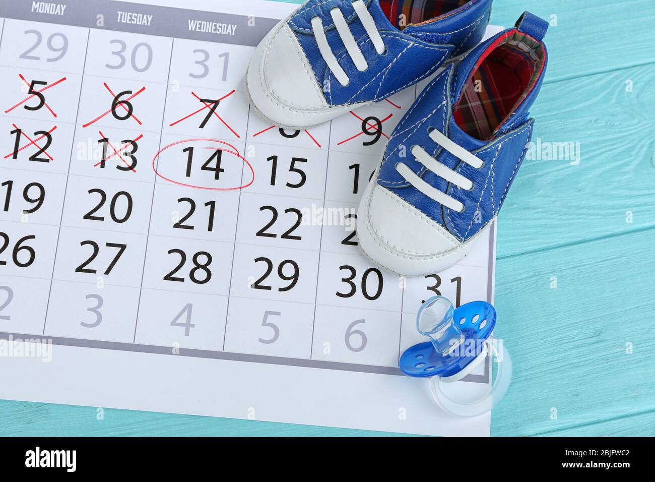 Calendar with baby booties on wooden background Stock Photo - Alamy