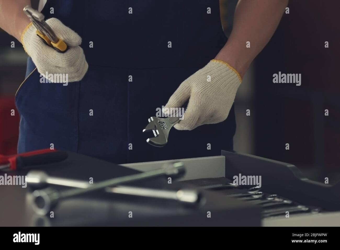Auto mechanic selecting tools in car repair shop, closeup Stock Photo ...