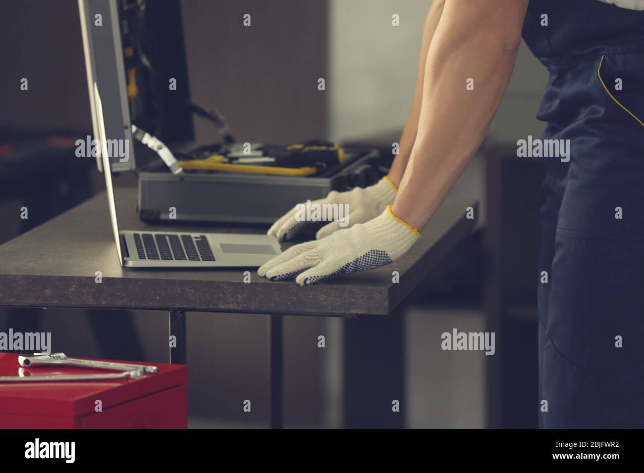 Auto mechanic working with laptop in car repair shop Stock Photo - Alamy