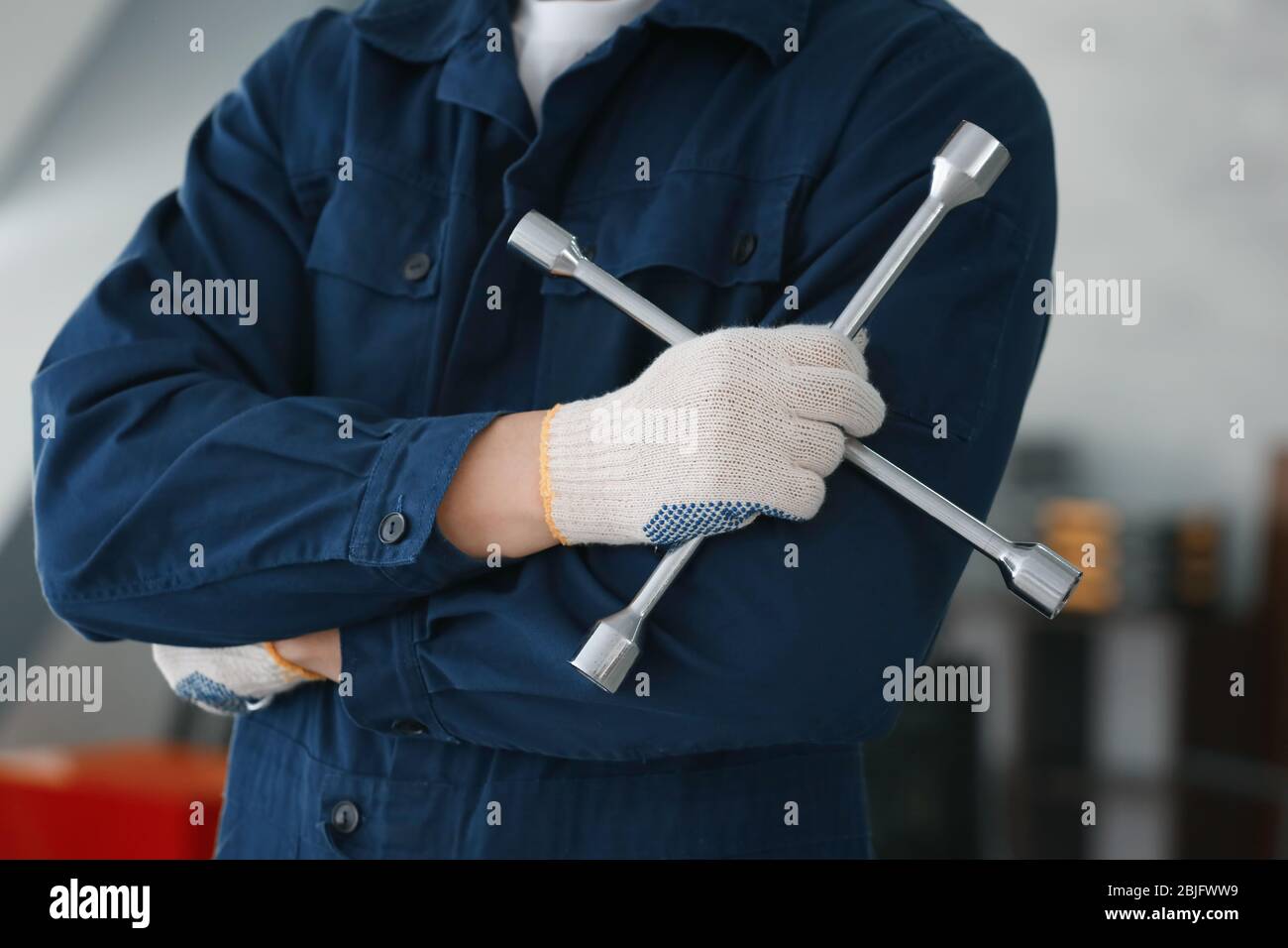 Auto mechanic with wheel wrench in car repair shop, closeup Stock Photo ...