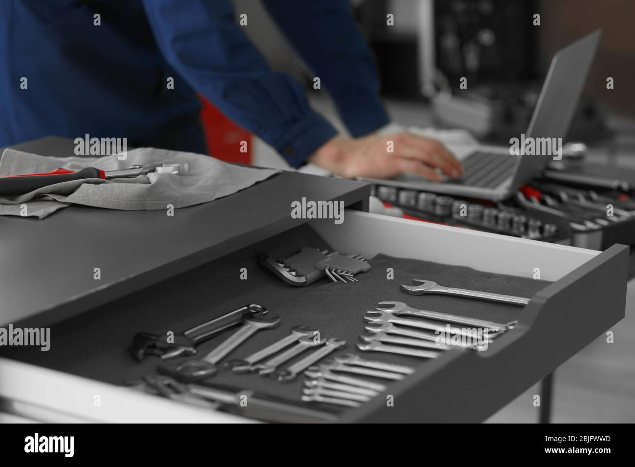 Drawer unit with tools and auto mechanic on background Stock Photo - Alamy