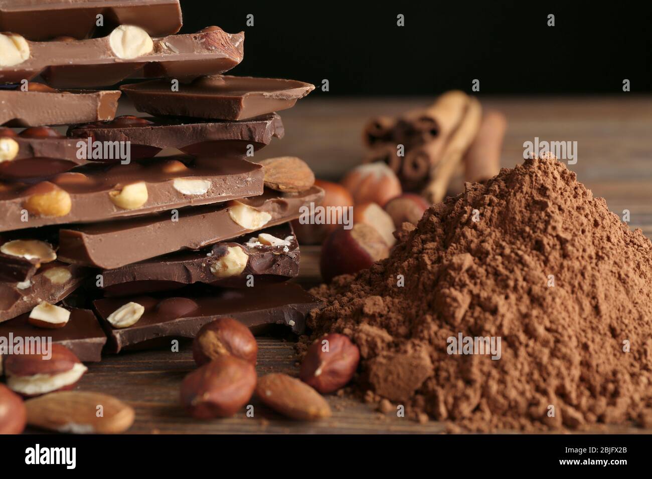 Chopped chocolate bars with nuts and cocoa powder, closeup Stock Photo ...