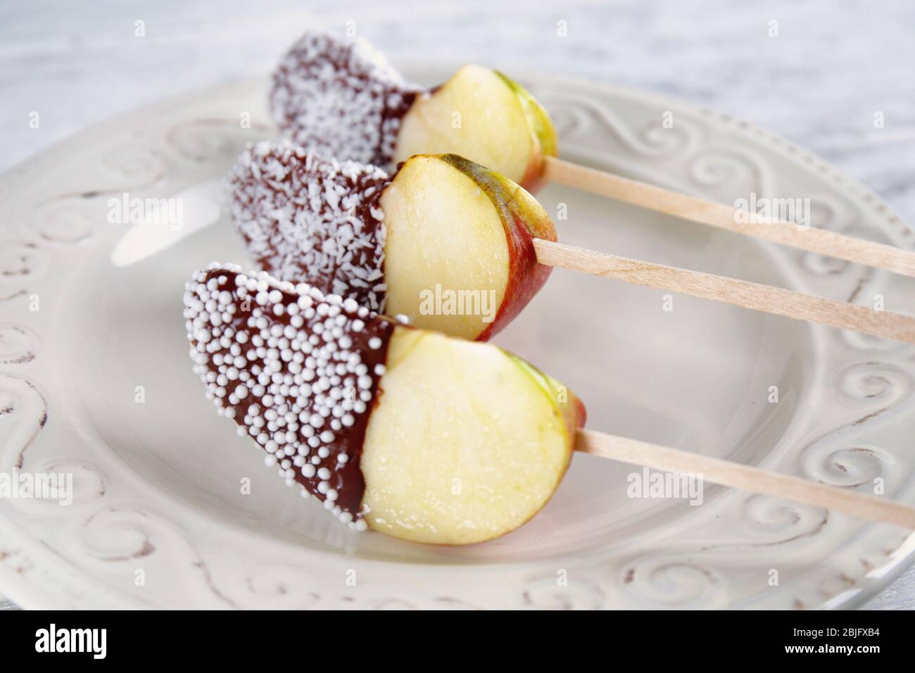 Plate with candied apple wedges on sticks Stock Photo - Alamy