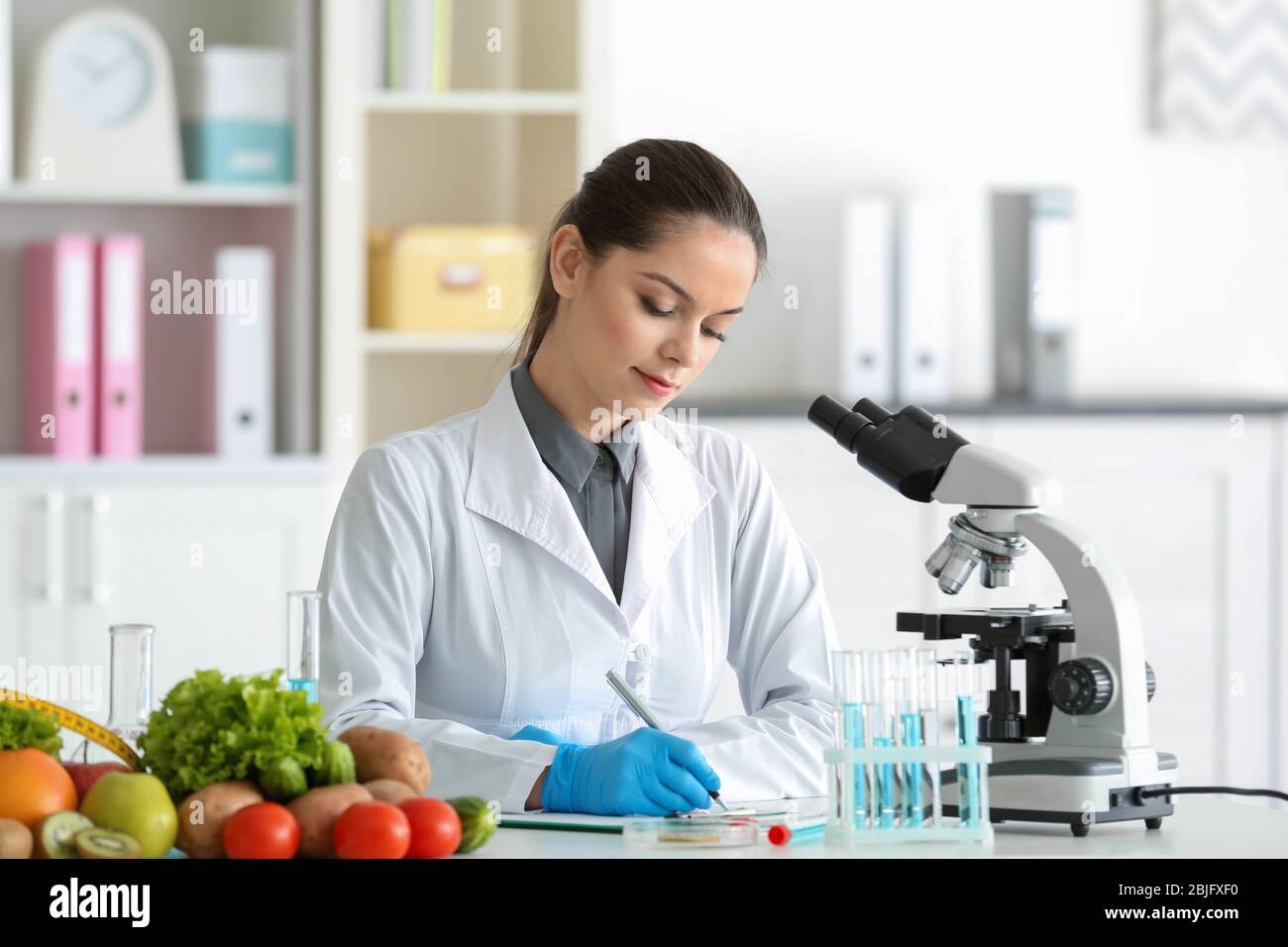 Young female nutritionist testing food samples in laboratory Stock ...