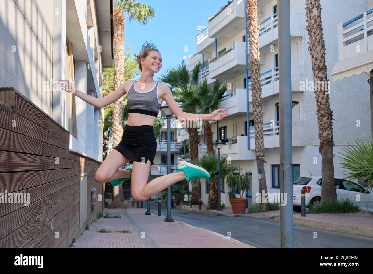 Beautiful sports girl teenager jumping, flying in air, street ...