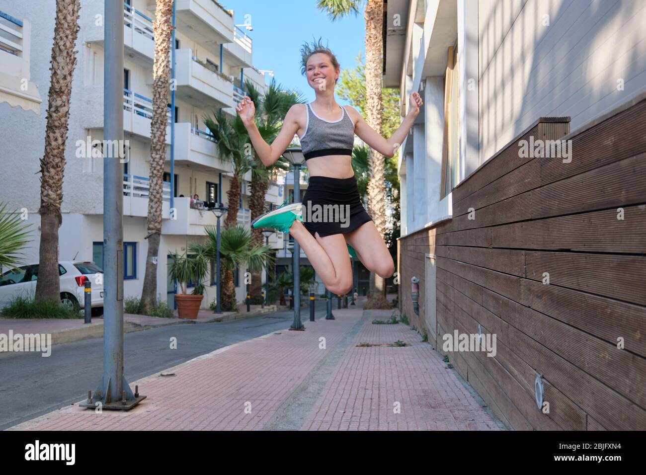Beautiful sports girl teenager jumping, flying in air, street ...